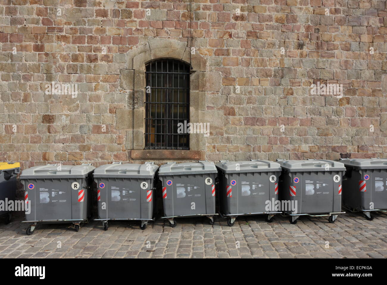 Trash bins lined up against the brick wall in Barcelona, Catalunya ...