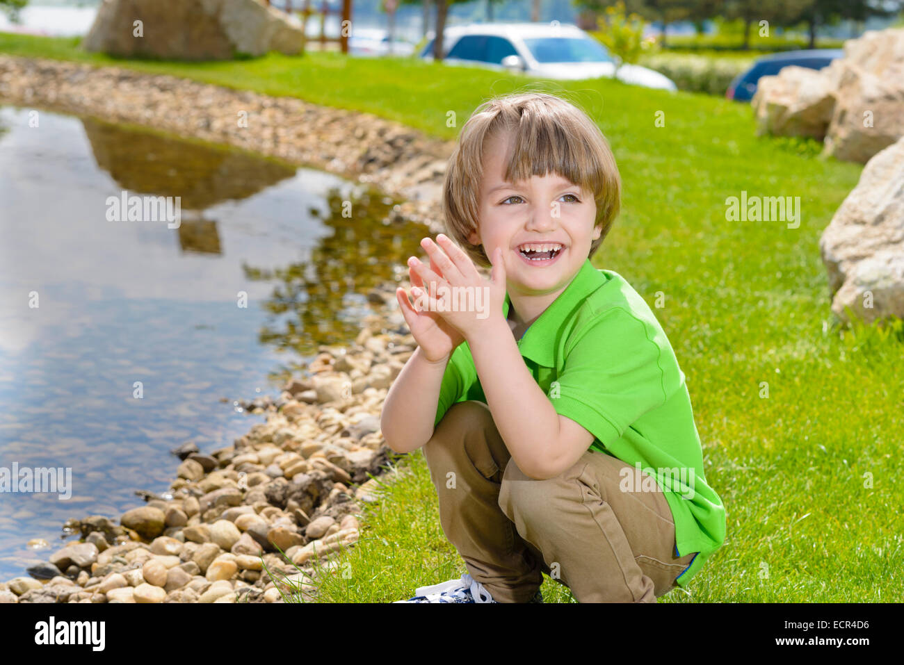 Beautiful boy throwing stones into the water Stock Photo - Alamy