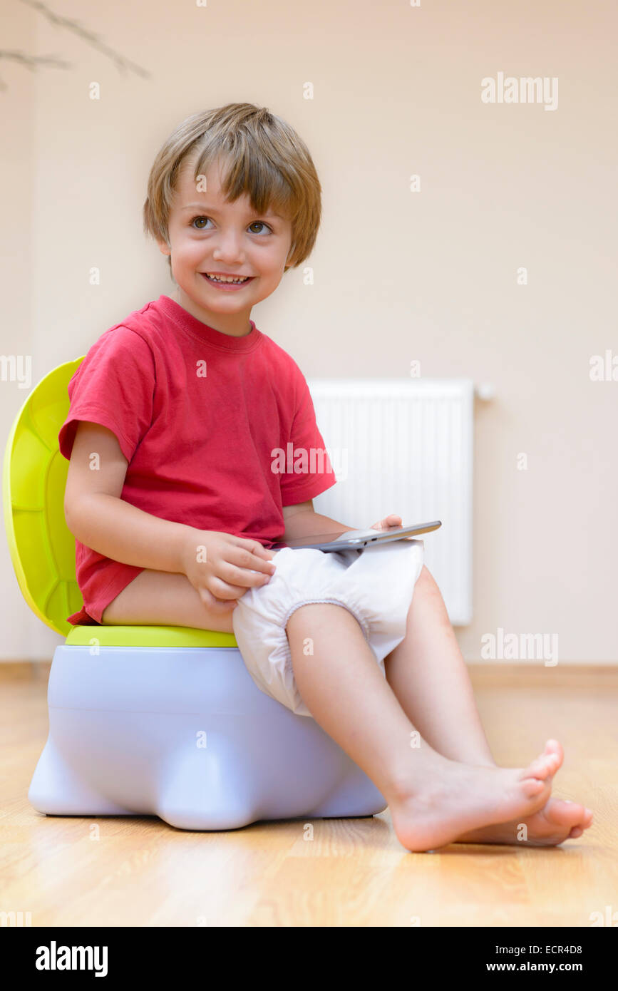 Boy on potty using tablet pc Stock Photo - Alamy