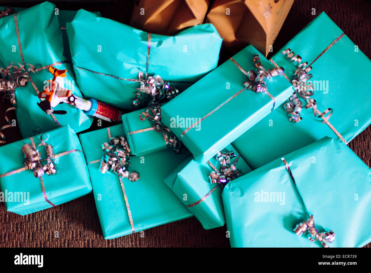 Pile of Christmas gifts on floor wrapped in turquoise gift wrap Stock ...