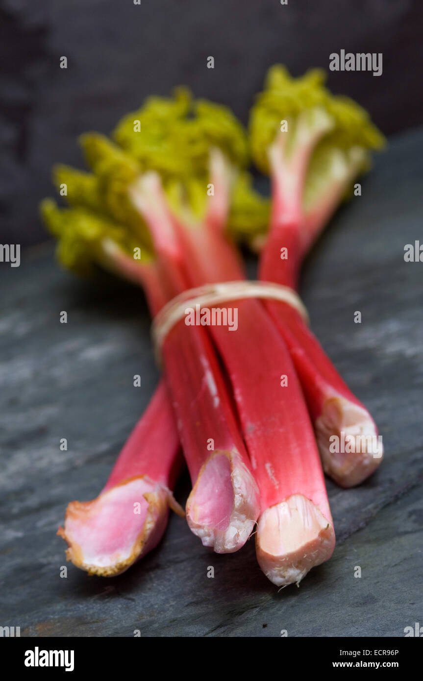 Fresh rhubarb tied in bunches and in a trug basket. A tart red food ...