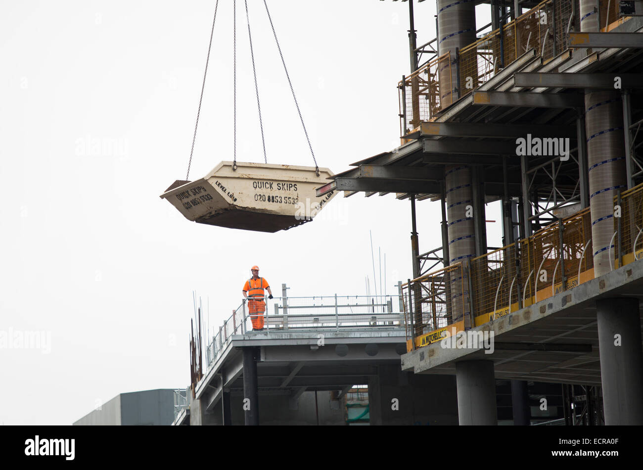 Skip hoisted onto roof building site by crane Stock Photo - Alamy