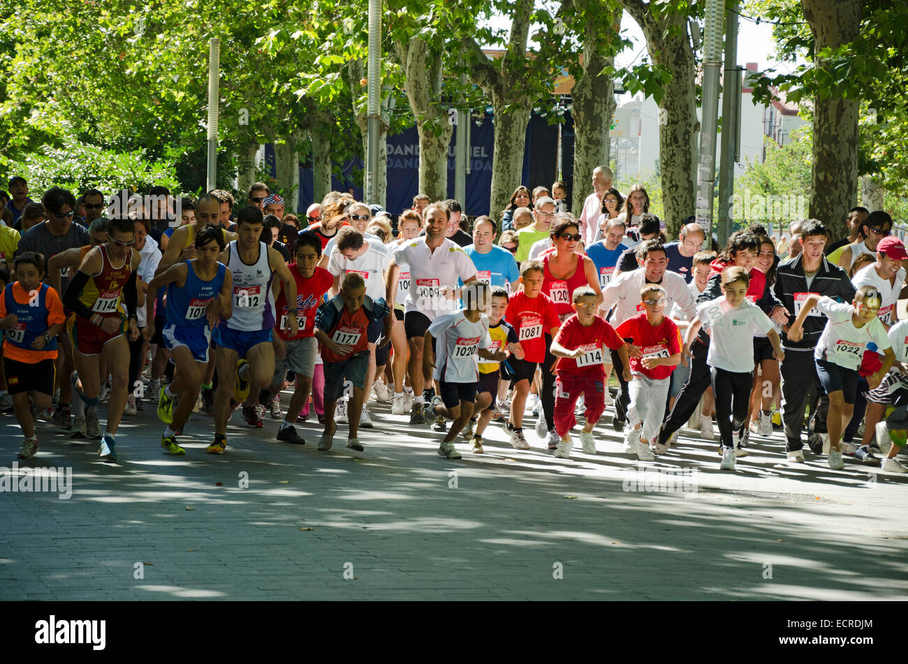 A larger number of runners all ages break from the starting line at the ...