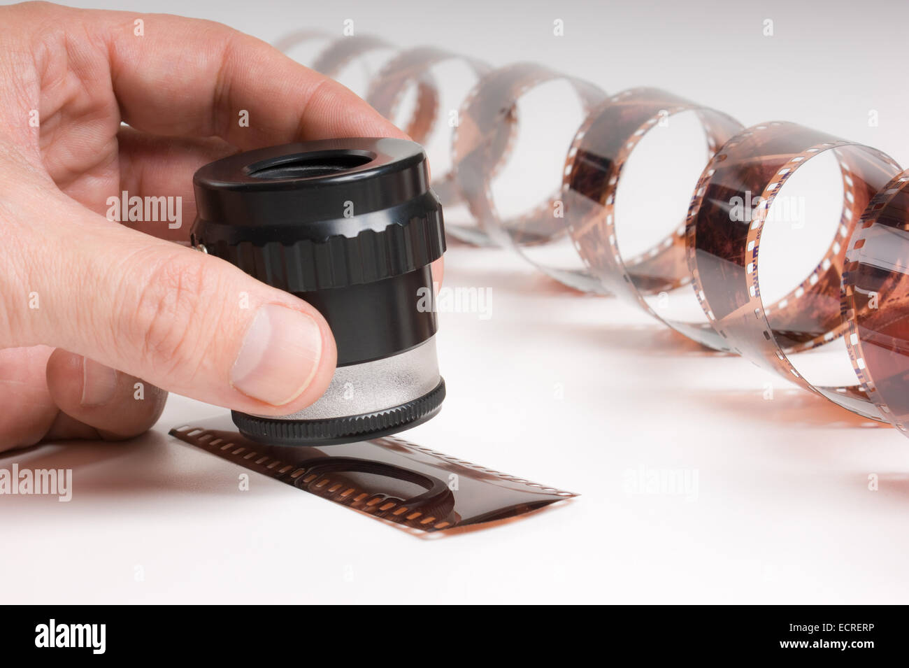 hand holding a magnifying glass and twisted film Stock Photo - Alamy