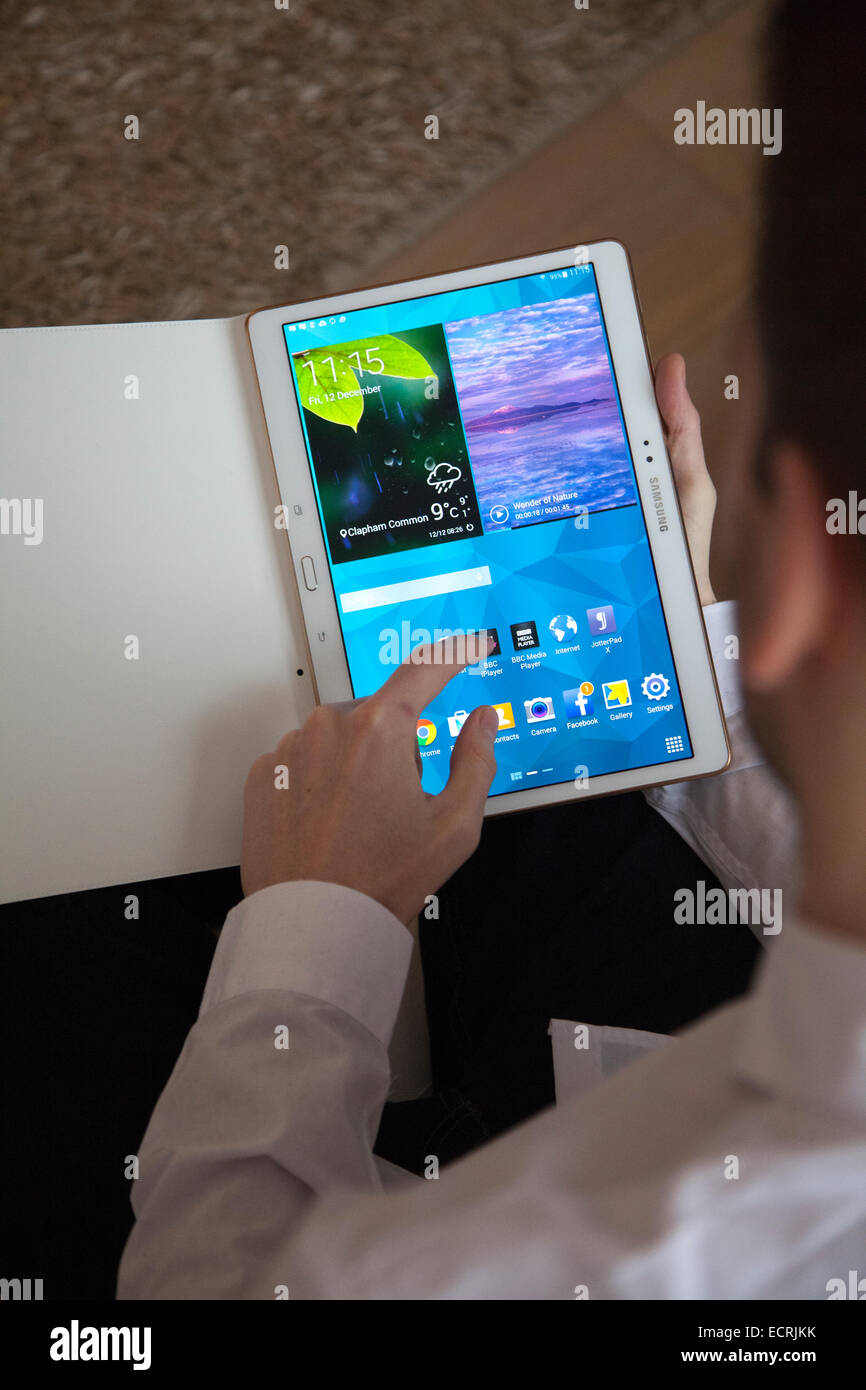 Man with Hand held Samsung 10.5 Tab S on Couch - UK Stock Photo - Alamy