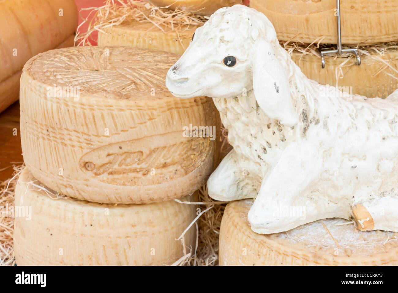 Stacked circular blocks of cheese with sheet statuette and straw Stock ...