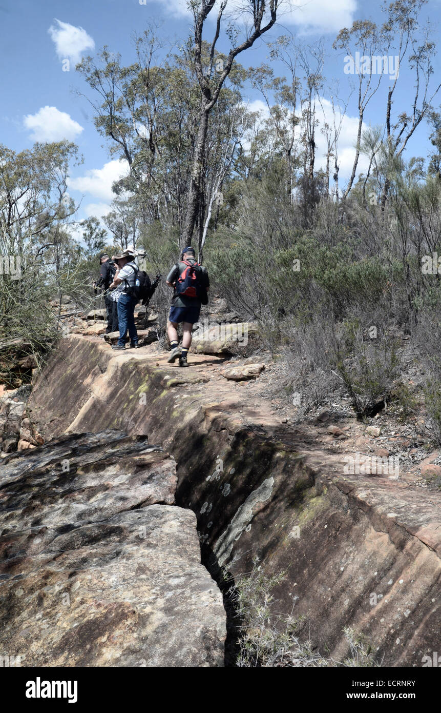 Hikers walking along edge of a cliff, Pilliga Forest NSW Australia ...