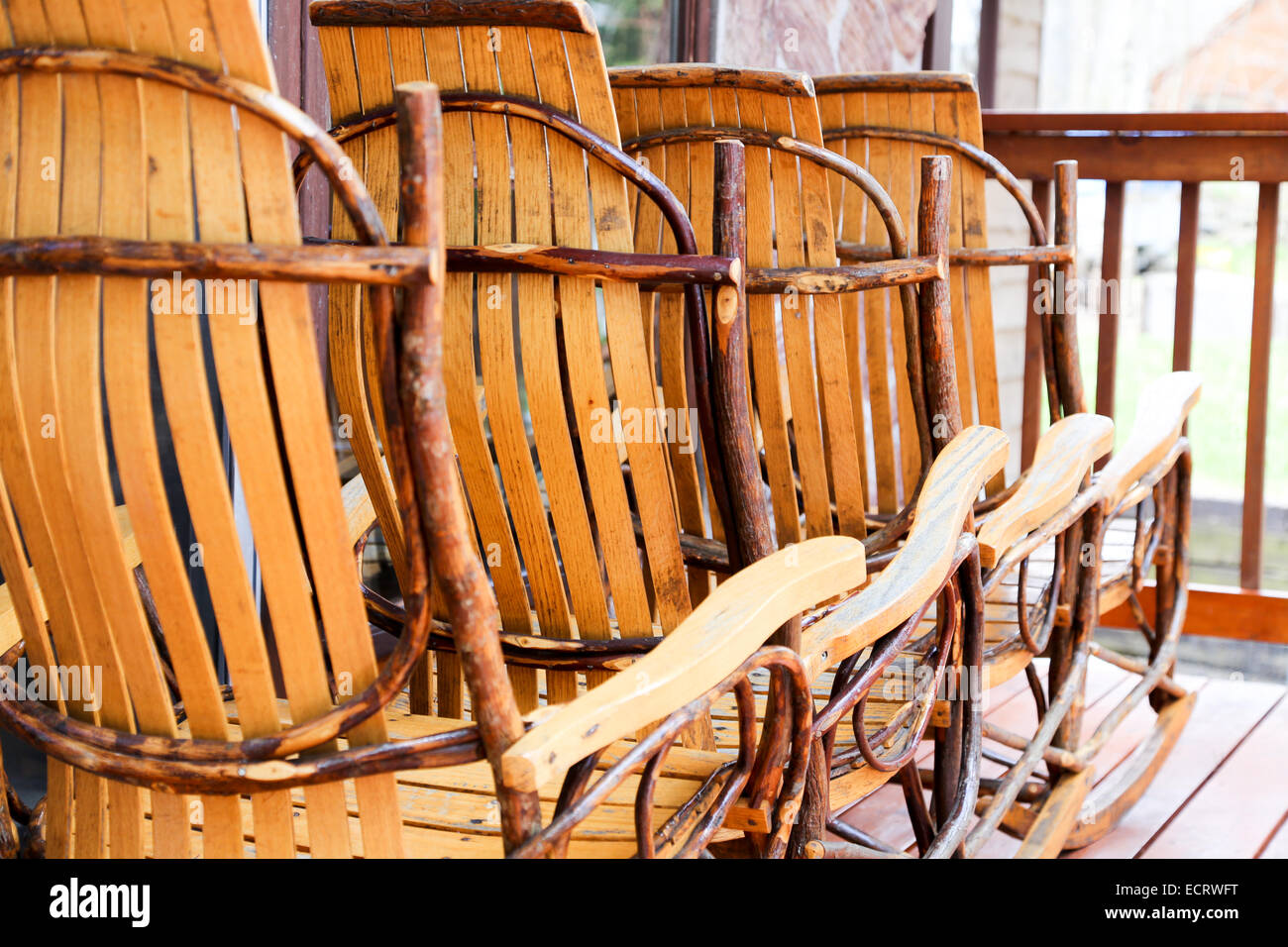 rustic wooden rockers lined up under the cottage porch roof, to protect ...