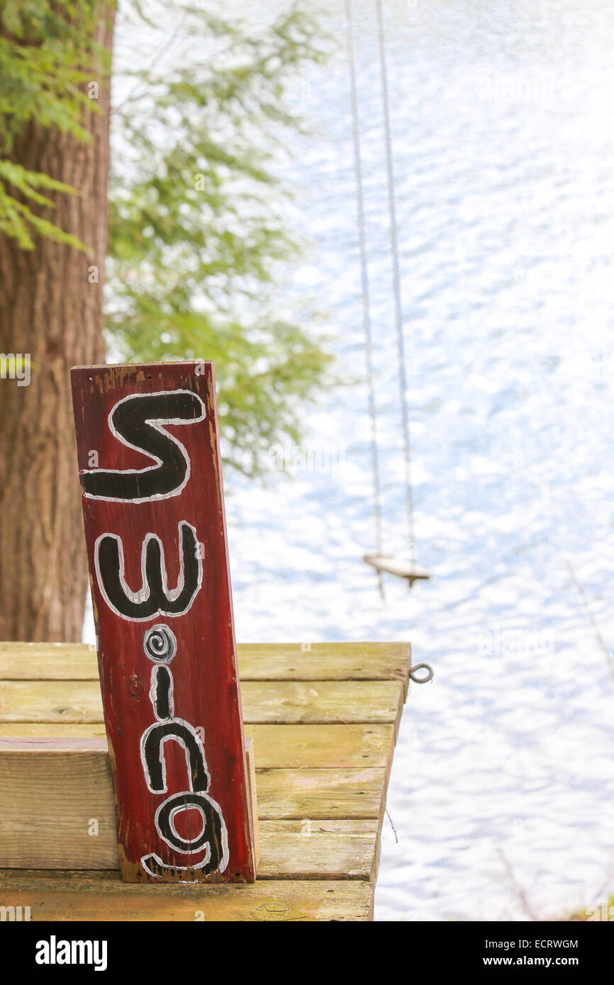 hand painted sign marks the jumping off point for the tree swing at the ...