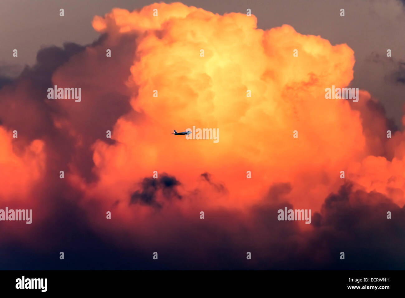 Airplane flies through dramatic red clouds Stock Photo - Alamy