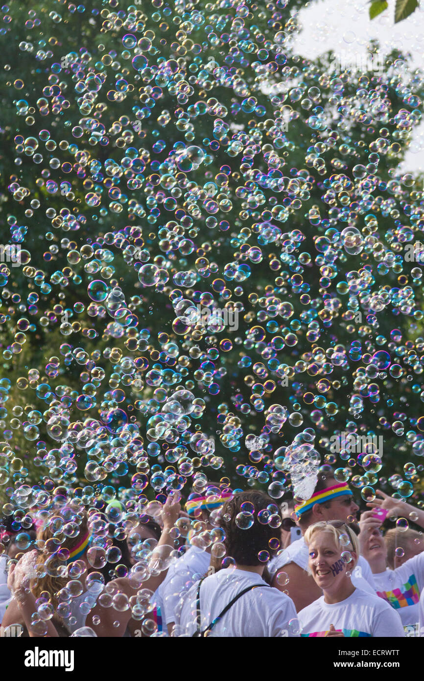 Happy Color Run participants surrounded by a colorful cloud of soap ...
