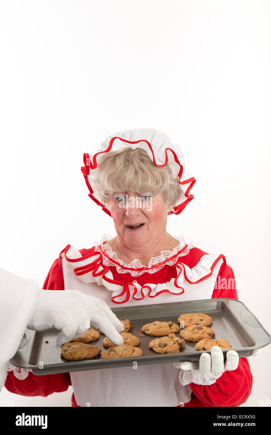 A white gloved hand of Santa reaches into the frame to steal a cookie ...
