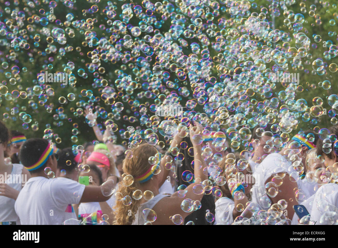 Happy Color Run participants have fun popping a cloud of colorful ...