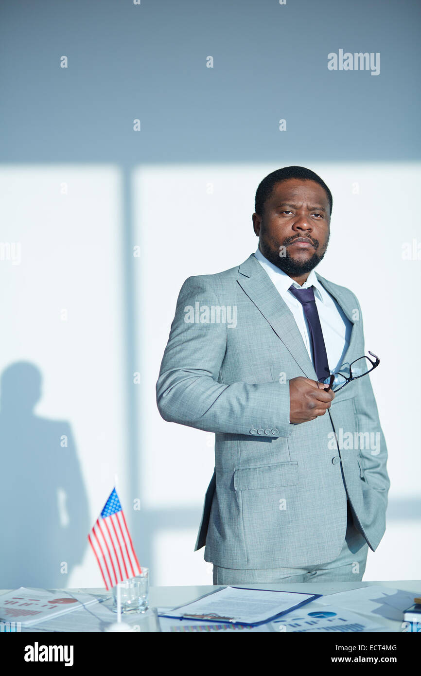 African-american employee in suit standing in office Stock Photo - Alamy