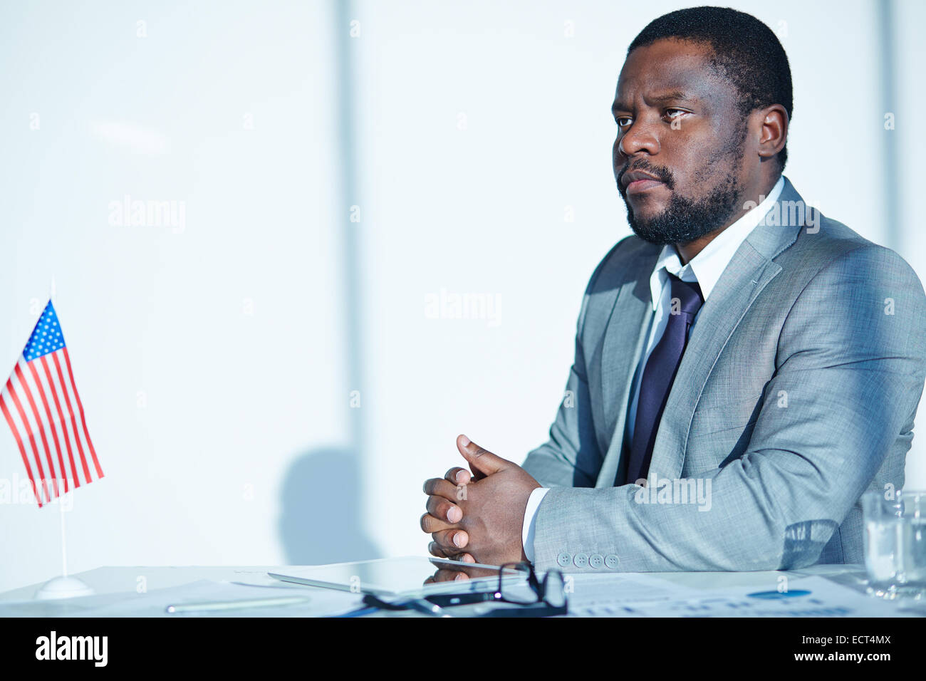 African-american serious entrepreneur sitting at workplace Stock Photo ...