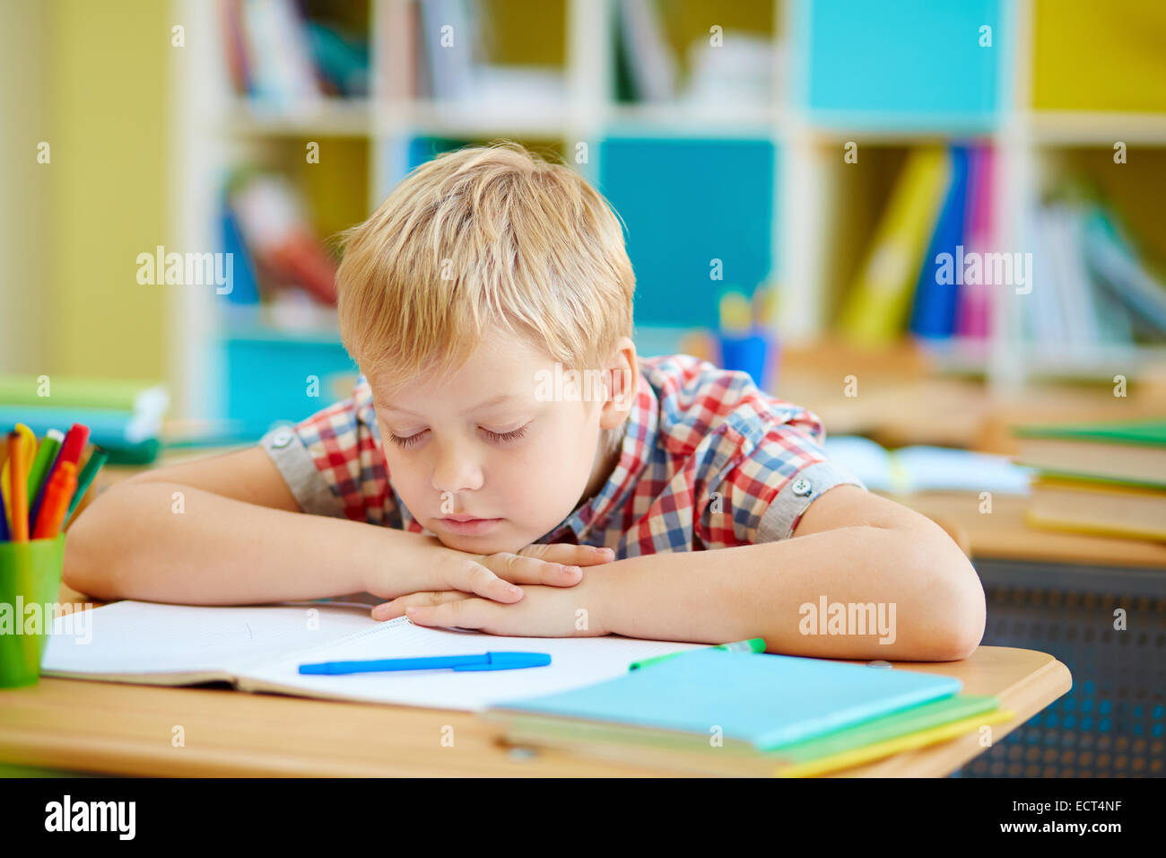 Cute boy napping by desk in classroom Stock Photo - Alamy