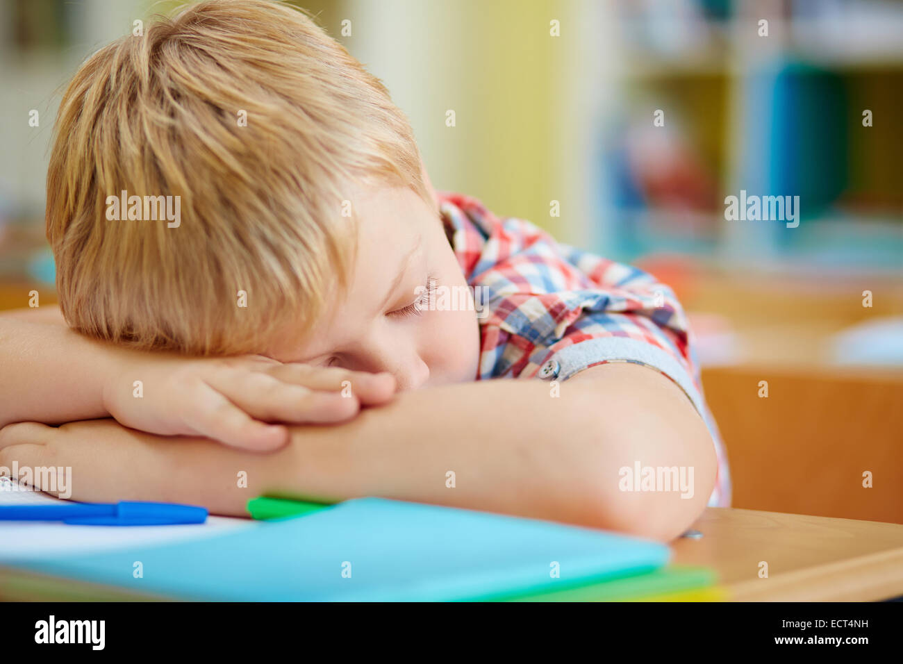 Tired little lad napping by desk in classroom Stock Photo - Alamy