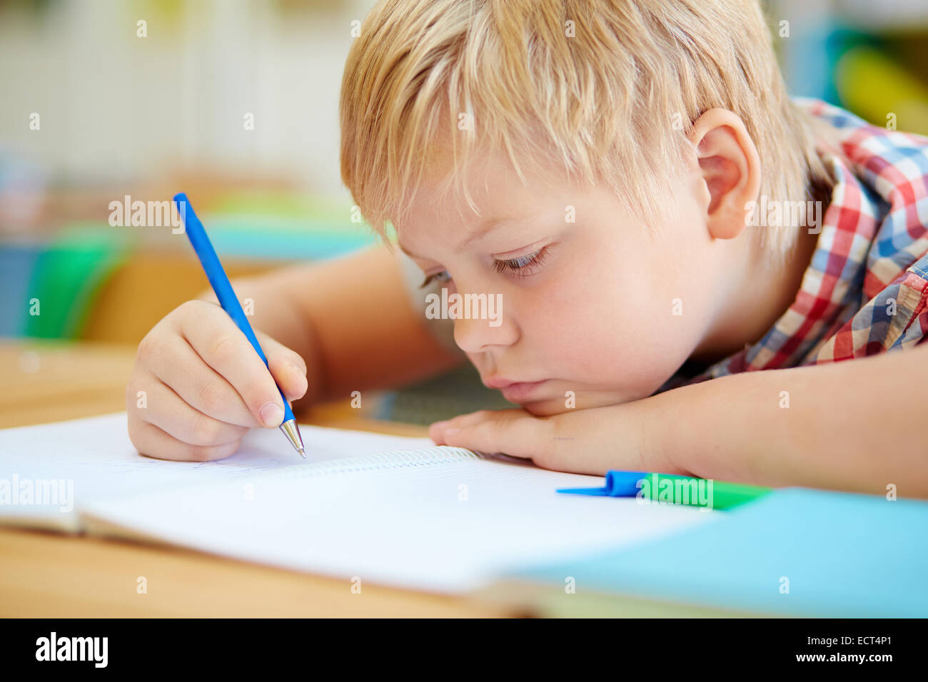 Cute learner making notes in copybook at lesson Stock Photo - Alamy
