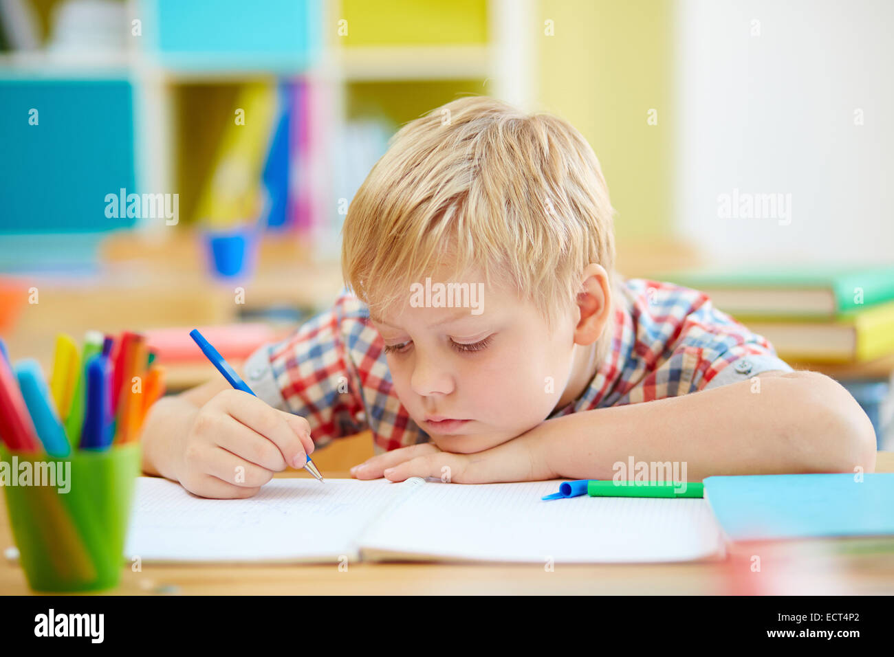 Youthful learner making notes or drawing with pen at lesson Stock Photo ...