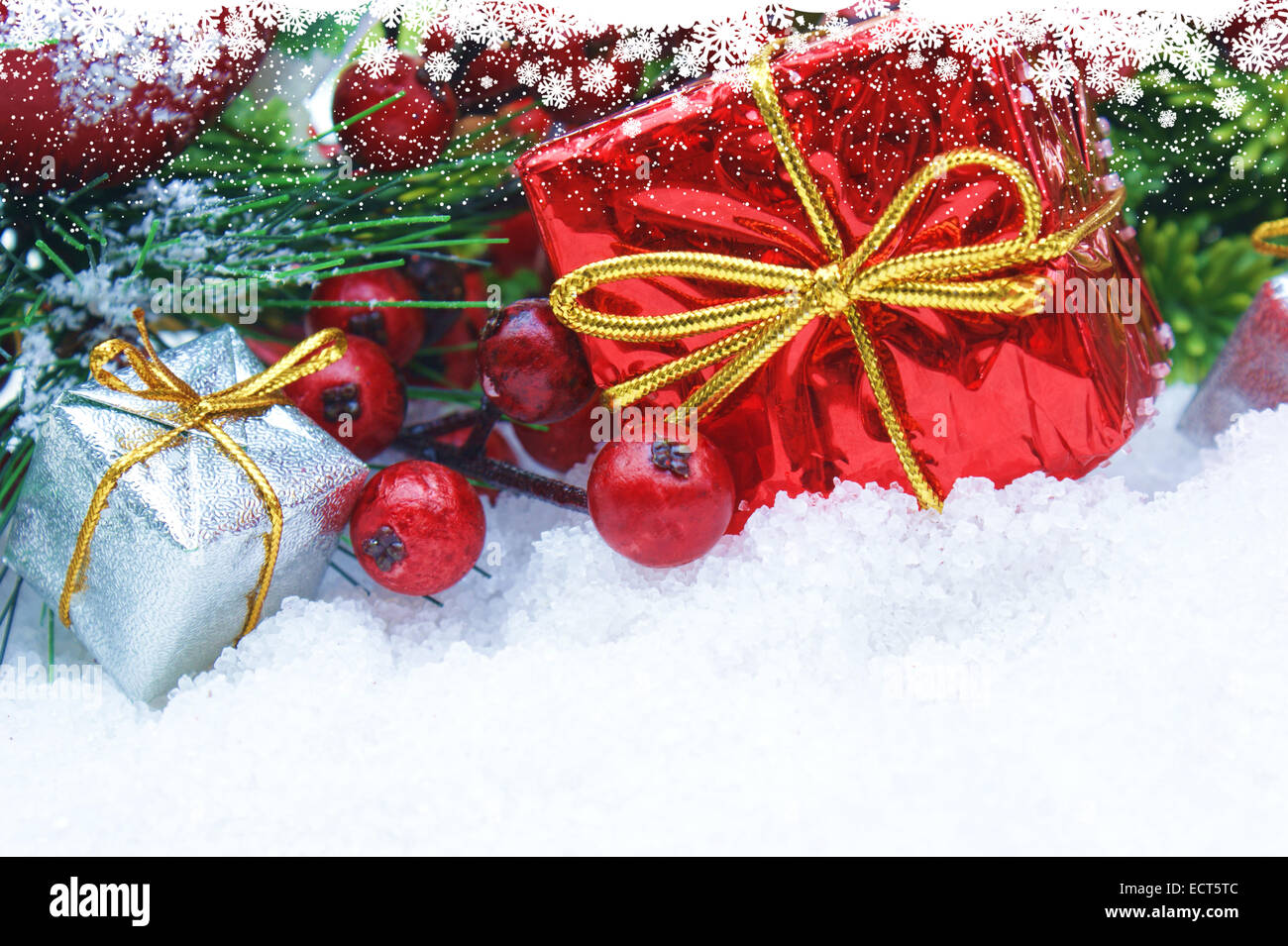 Christmas gifts and berries nestled in snow Stock Photo - Alamy