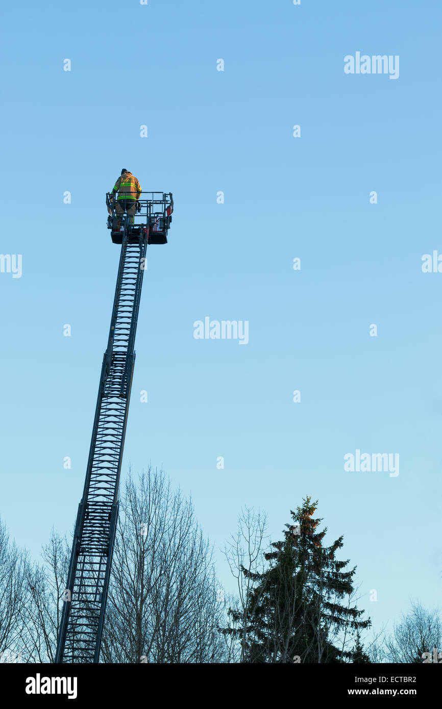 Swedish fireman in Stockholm, Sweden lit by sun as he tests firetruck ...