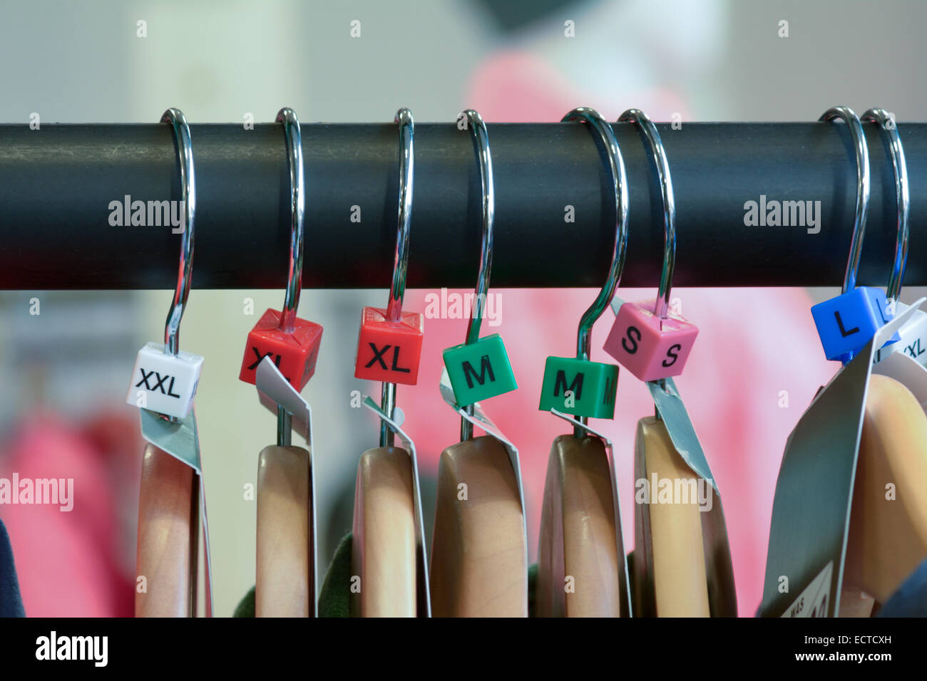 Hangers with clothes and sizes on clothes rail in shop Stock Photo - Alamy