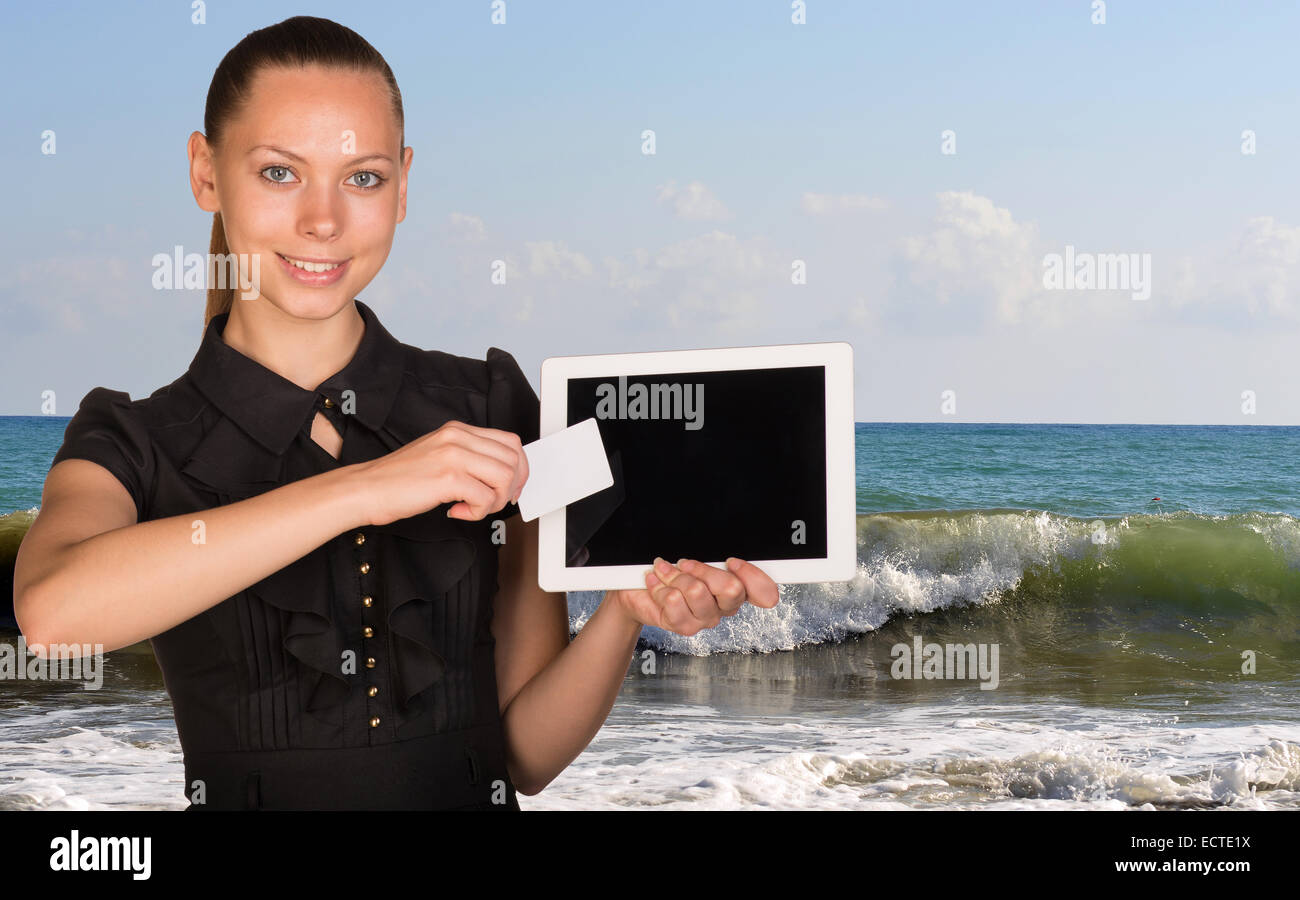 Beautiful businesswoman holding tablet PC and business card in front of ...