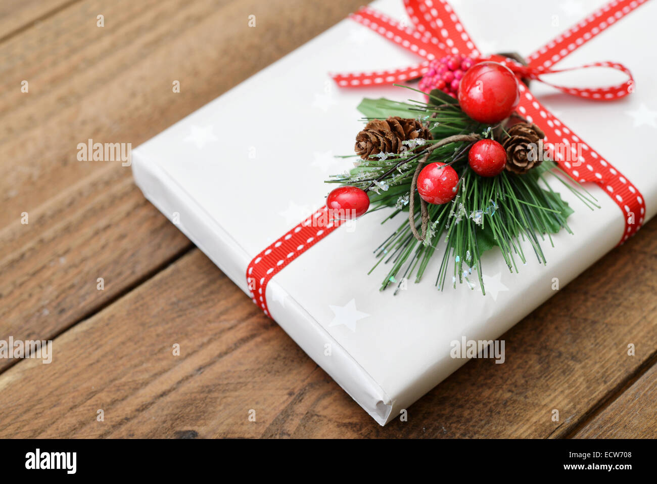 Christmas present wrapped in decorative wrapping paper with red ribbon ...
