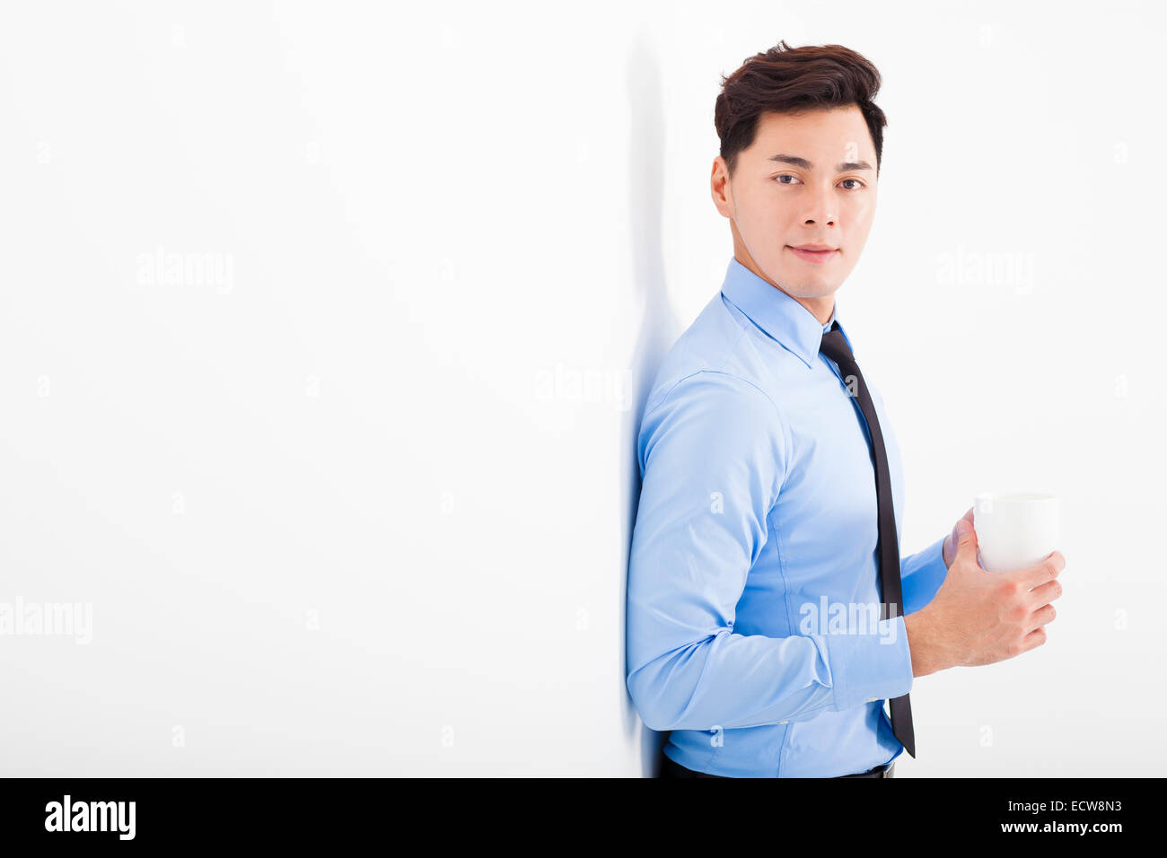 Businessman leaning against office wall hi-res stock photography and ...