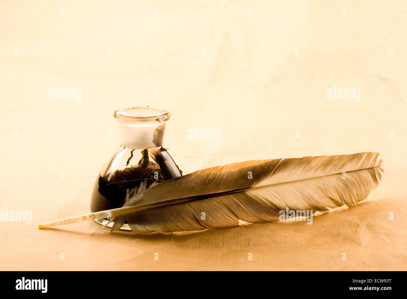 Feather and ink bottle isolated on paper background Stock Photo - Alamy