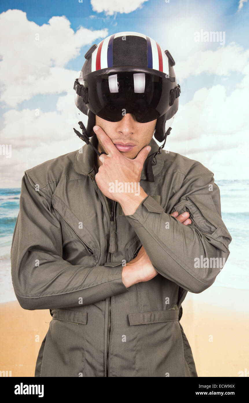 young handsome pilot wearing uniform and helmet over beach background ...