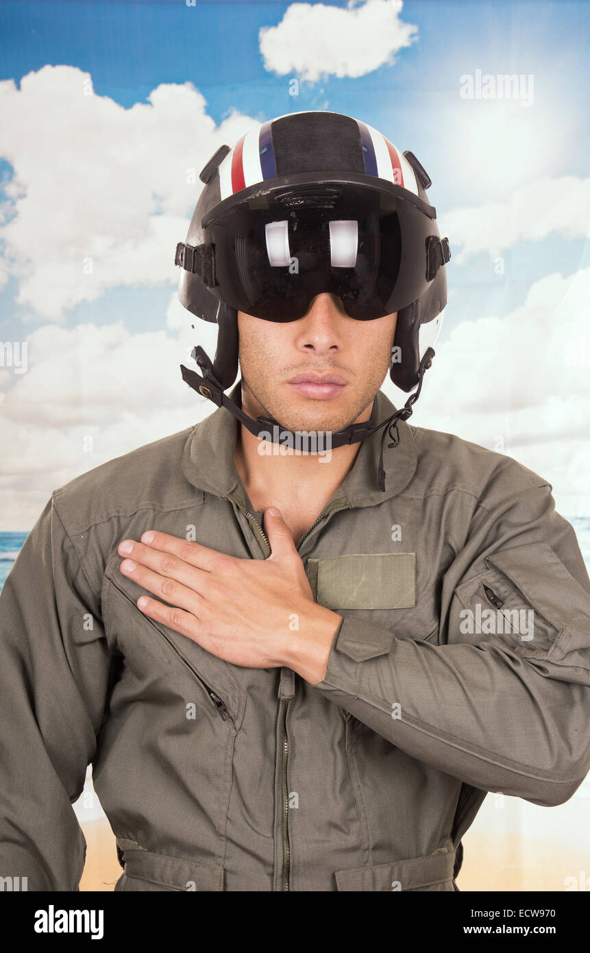 young handsome pilot wearing uniform and helmet over beach background ...
