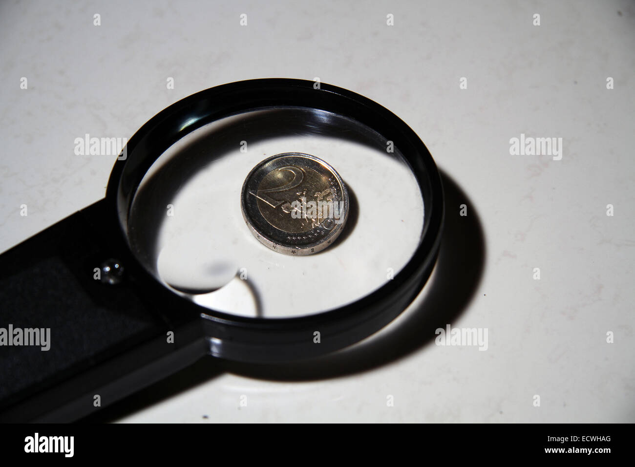 2 Euro Coin under Magnifying Glass Stock Photo - Alamy