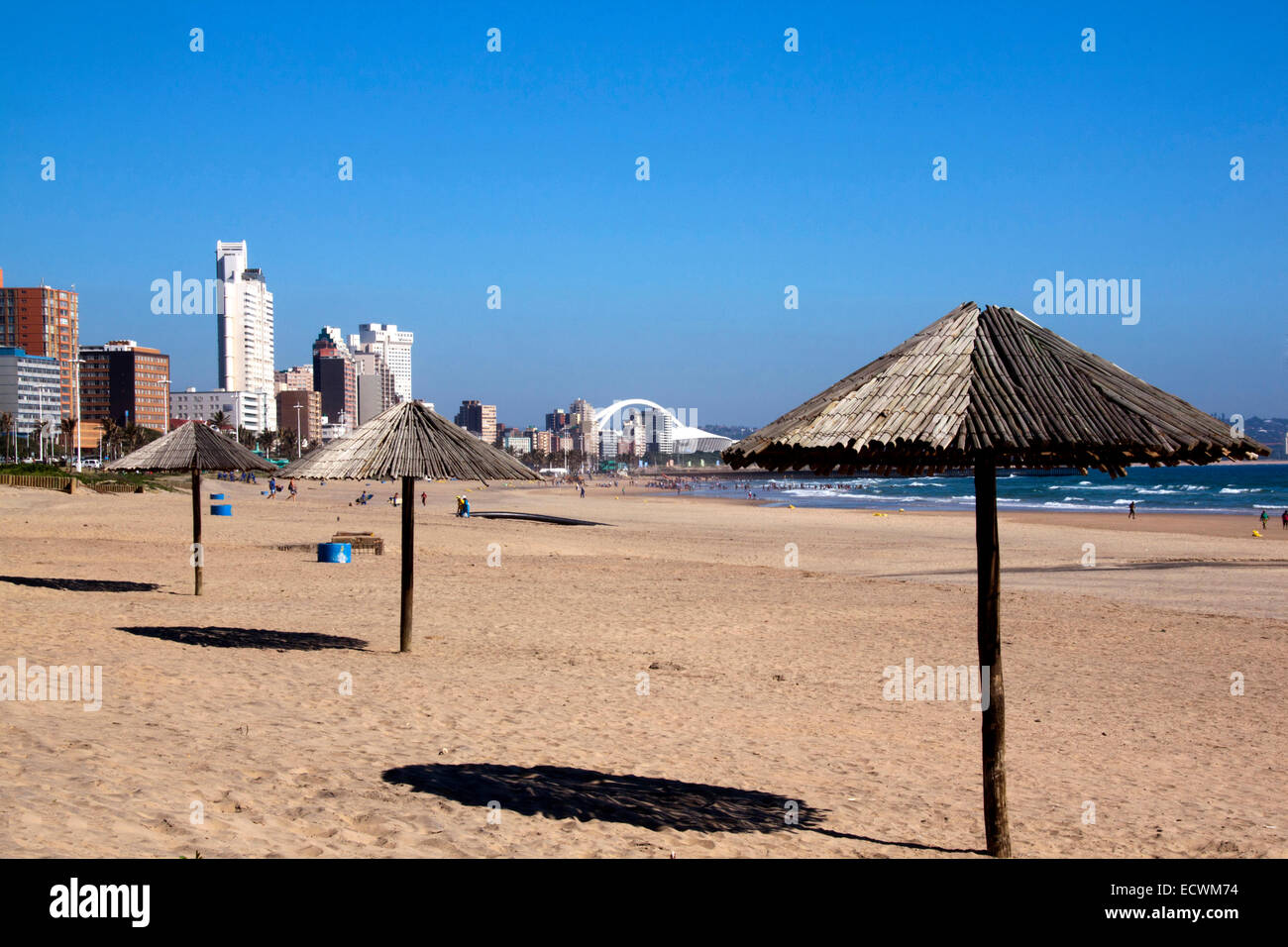 Three wooden sunshades and many unknown people on Addington Beach in ...