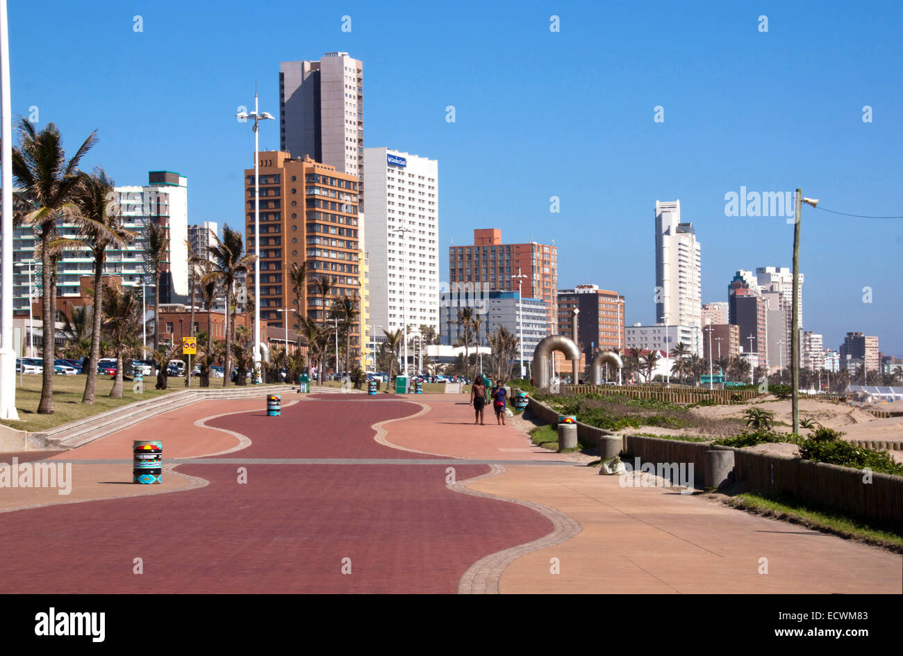 Two unknown people walk on promenade along Addington beach against ...