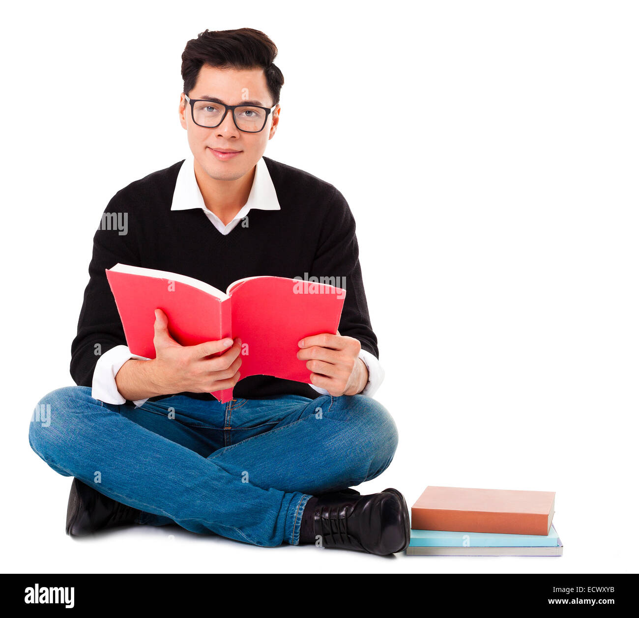 Smiling guy sitting on a floor and reading a book Stock Photo - Alamy