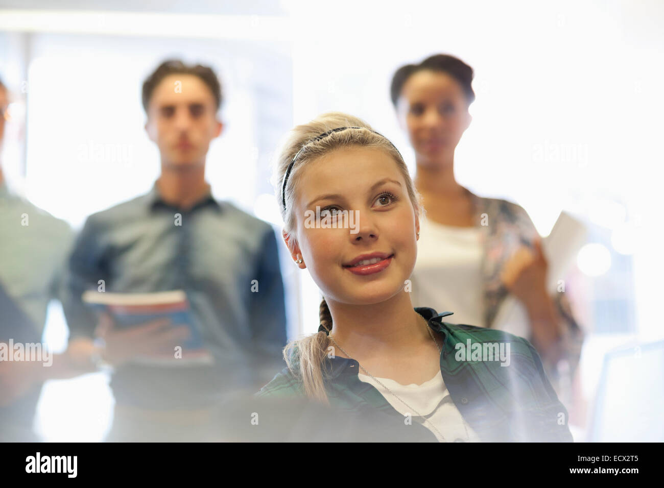 Four smiling university students inside classroom Stock Photo - Alamy