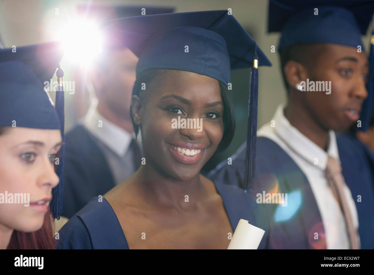 Portrait of university student holding diploma during graduation ...