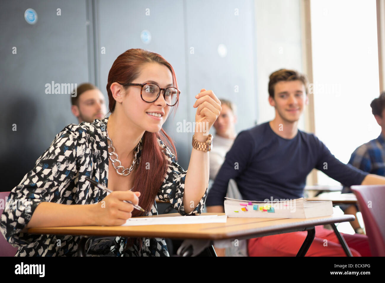 University student taking notes and listening during seminar in ...