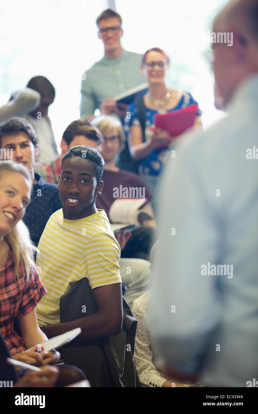 Focused students listening to professor at seminar in classroom Stock ...