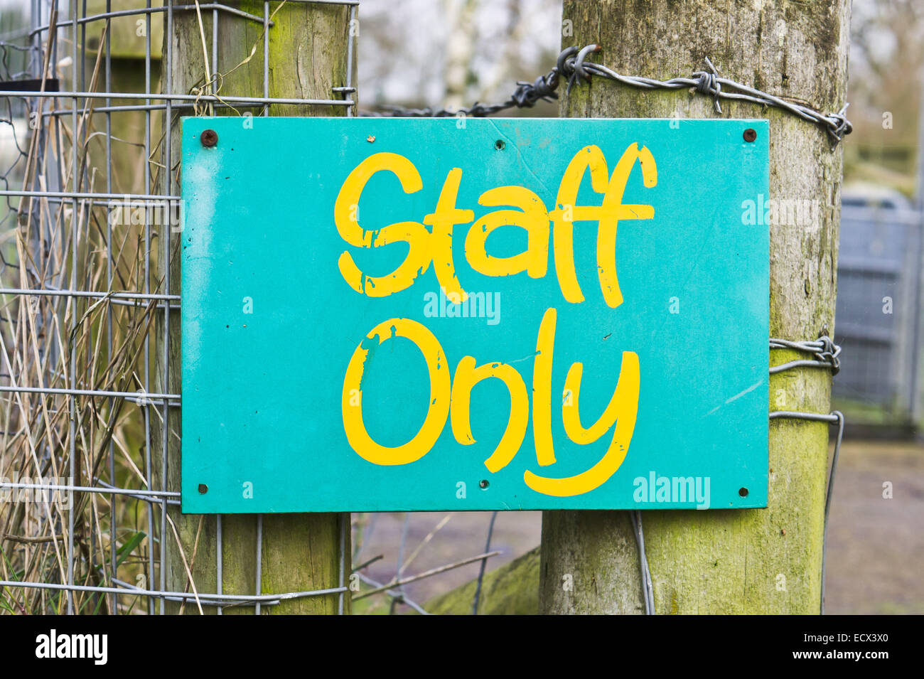 Green staff only notice on a wooden fence post Stock Photo - Alamy