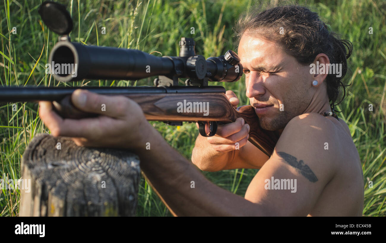 Man with rifle aiming at target Stock Photo - Alamy