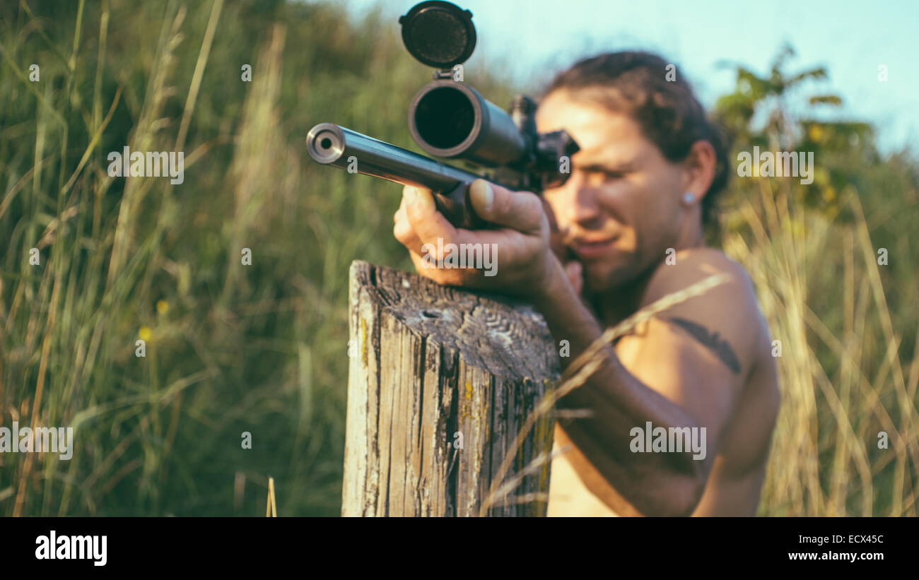 Man with rifle aiming at target Stock Photo - Alamy