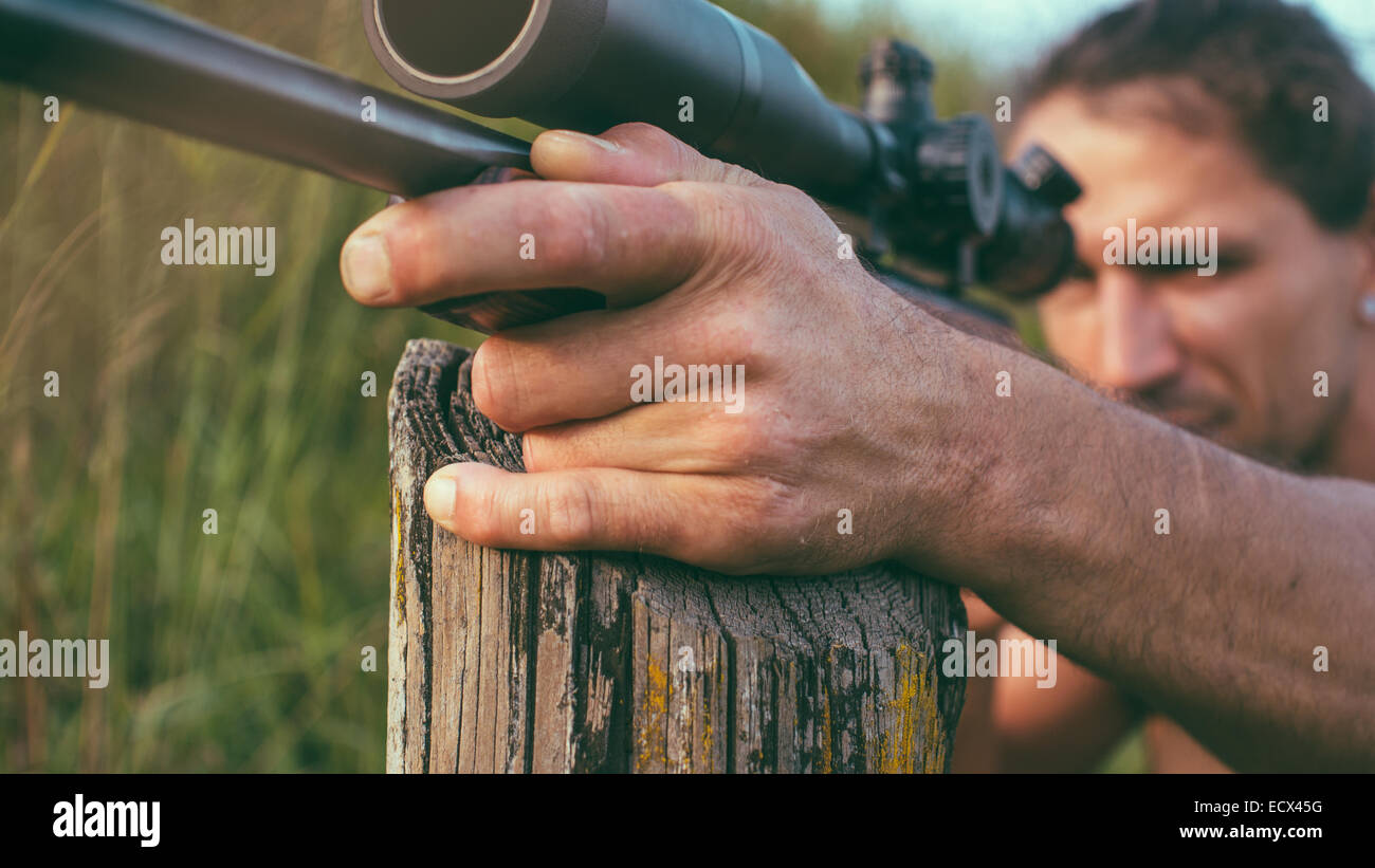 Man with rifle aiming at target Stock Photo - Alamy