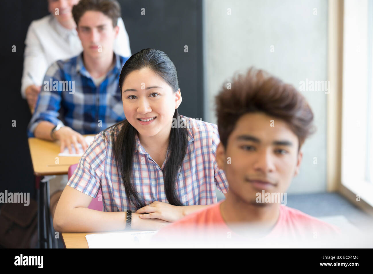Portrait of smiling university students sitting in classroom Stock ...