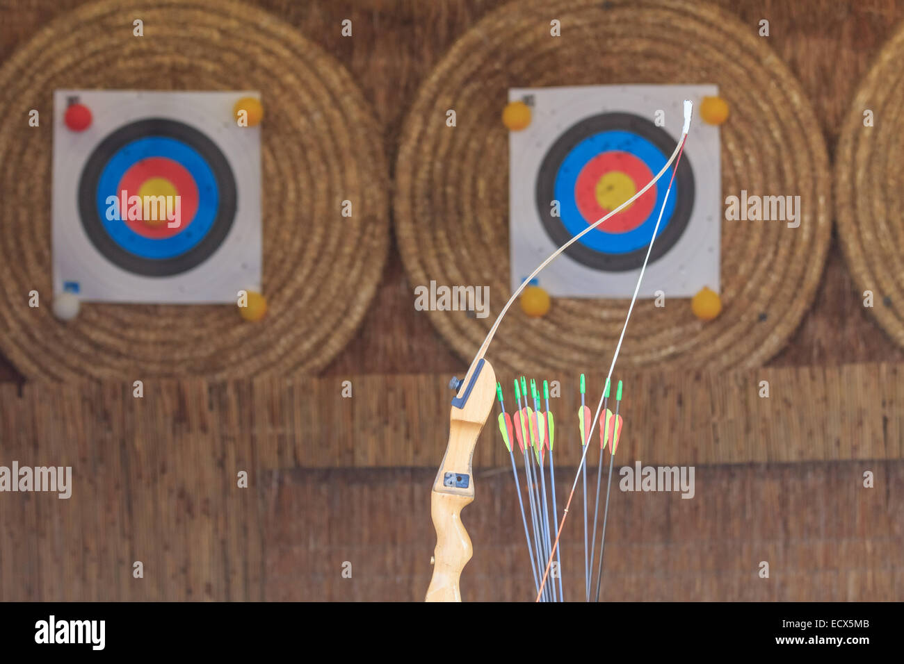 Archery bow and some arrows in front of targets Stock Photo - Alamy