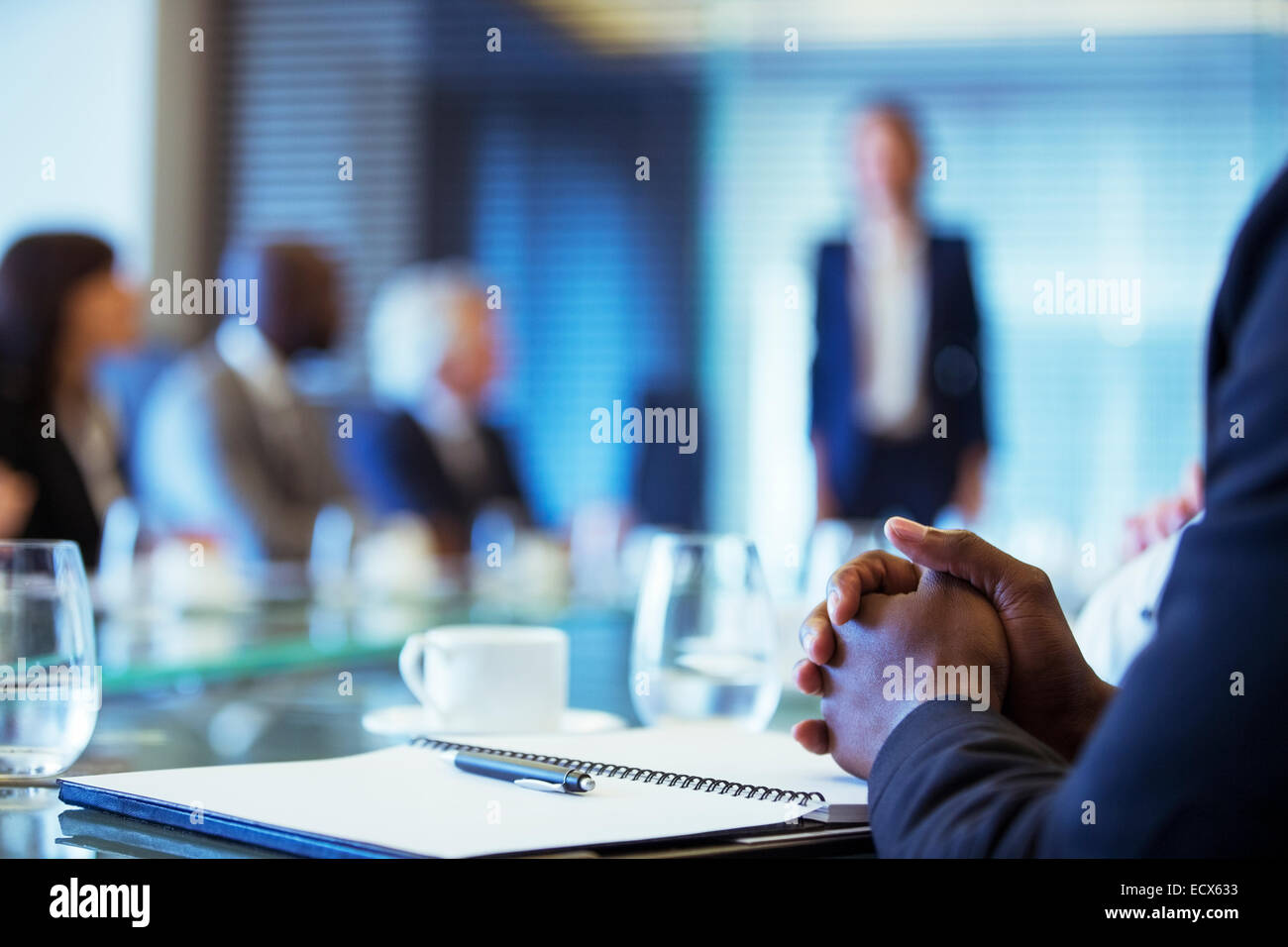 Businessman sitting at conference table in conference room with hands ...