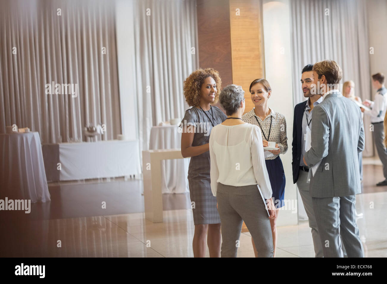 Business people standing in conference room, talking and smiling Stock ...