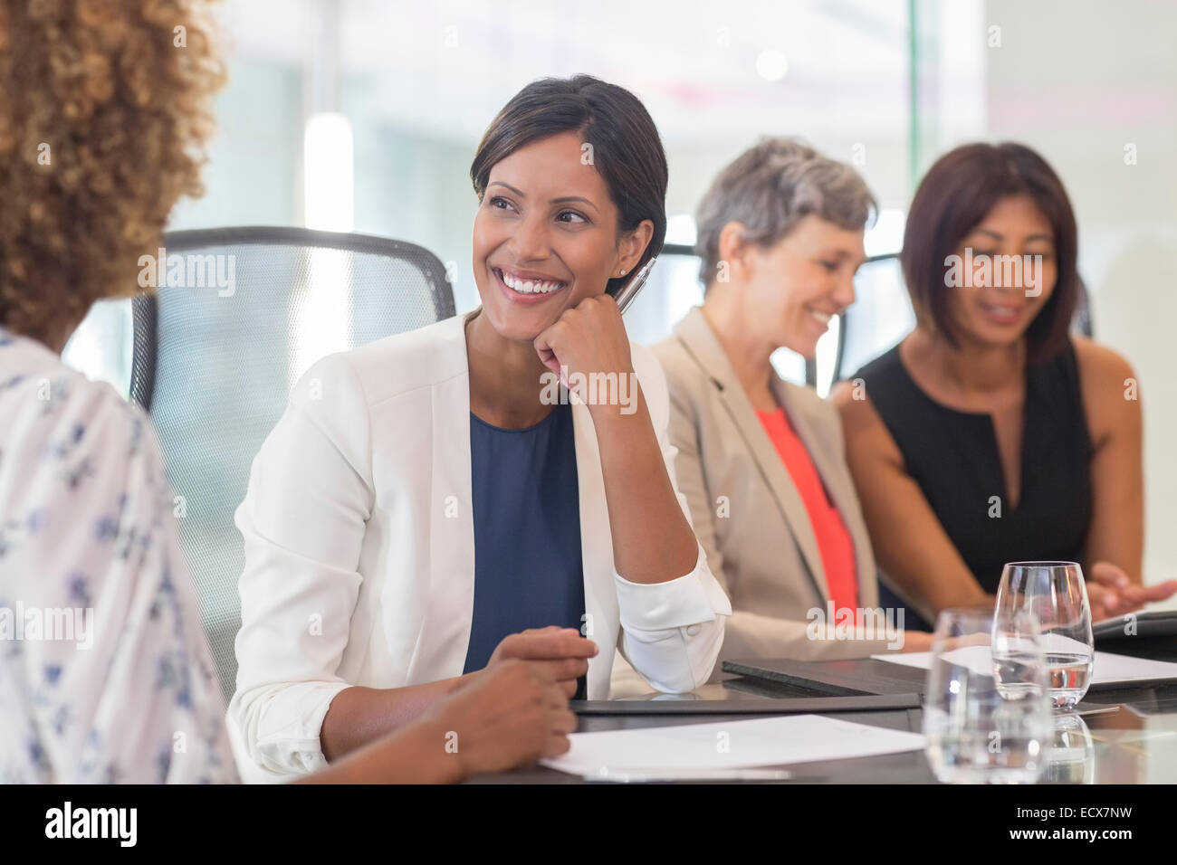 Four women sitting and talking at conference table Stock Photo - Alamy