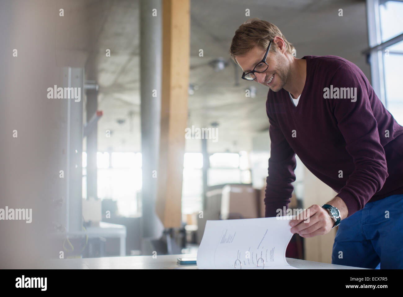 Businessman reading paperwork in office Stock Photo - Alamy